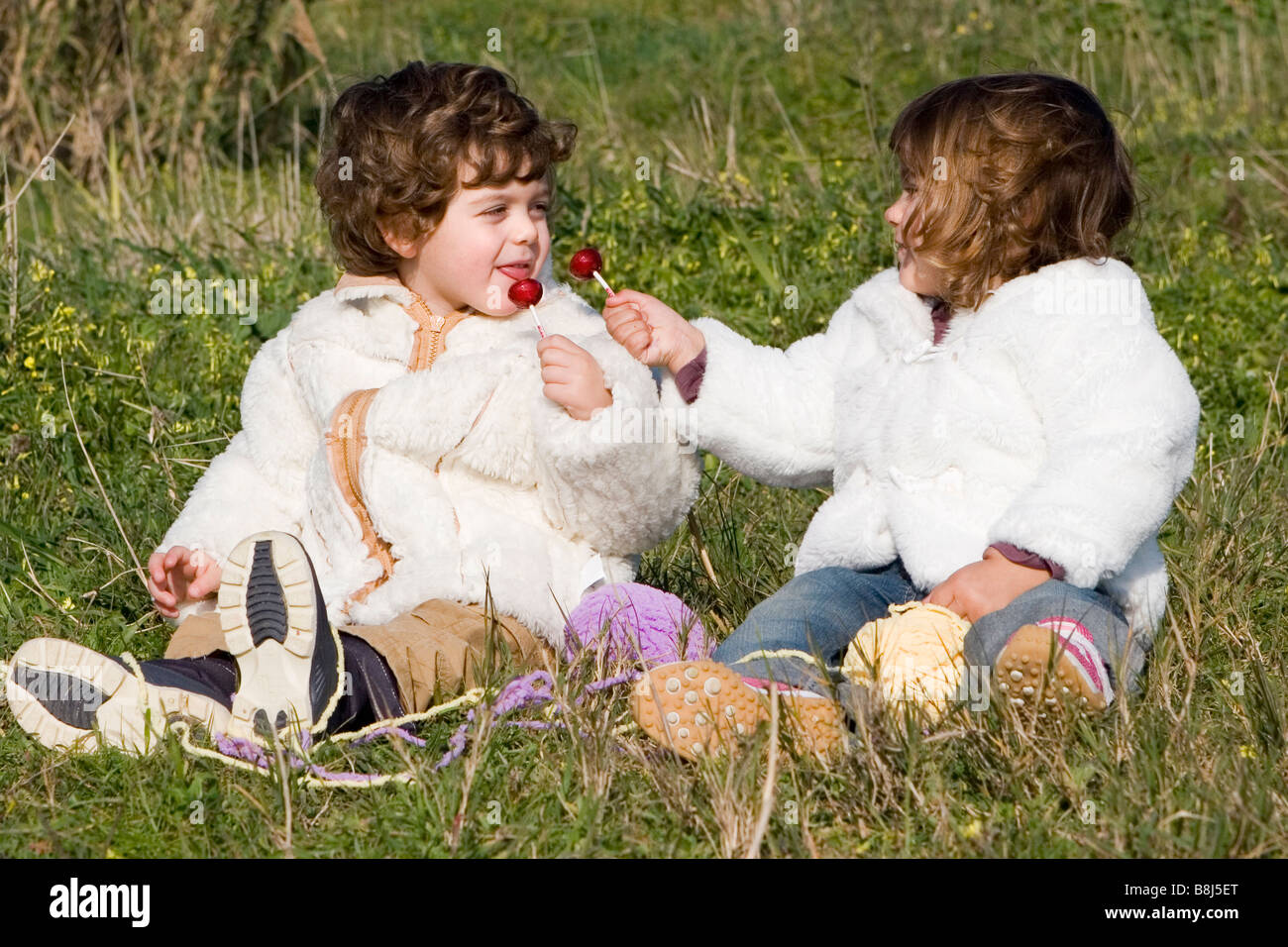 children sharing a sweet Stock Photo - Alamy