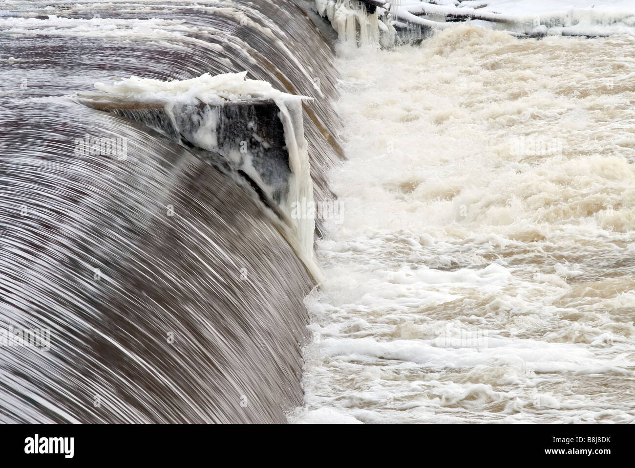 Rushing water and ice flowing over a dam on the Grand River Stock Photo ...