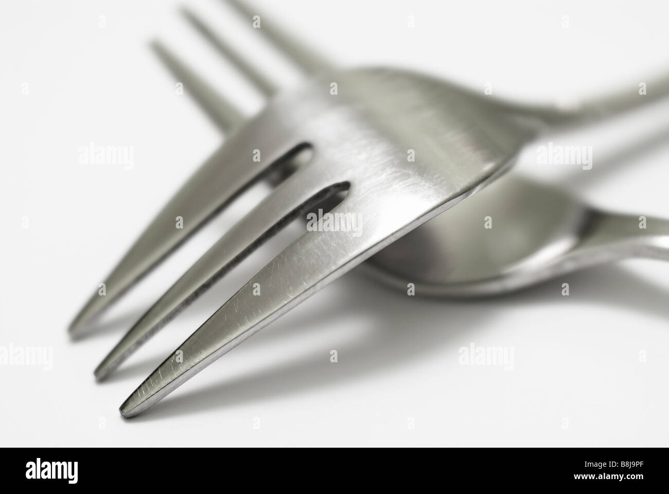 Two crossed forks on a white background Stock Photo - Alamy