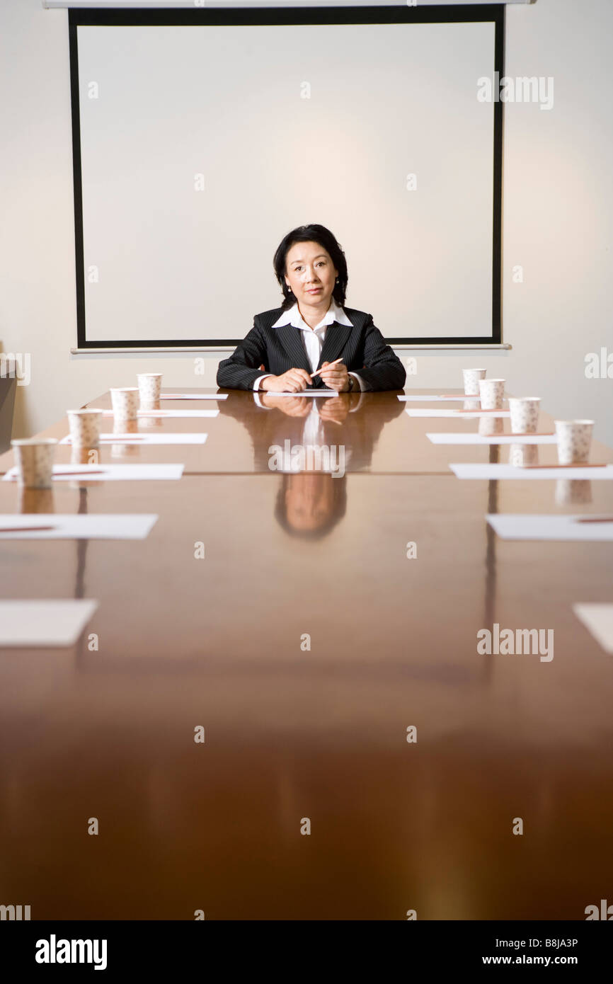 Businesswoman at head of table in boardroom portrait Stock Photo - Alamy