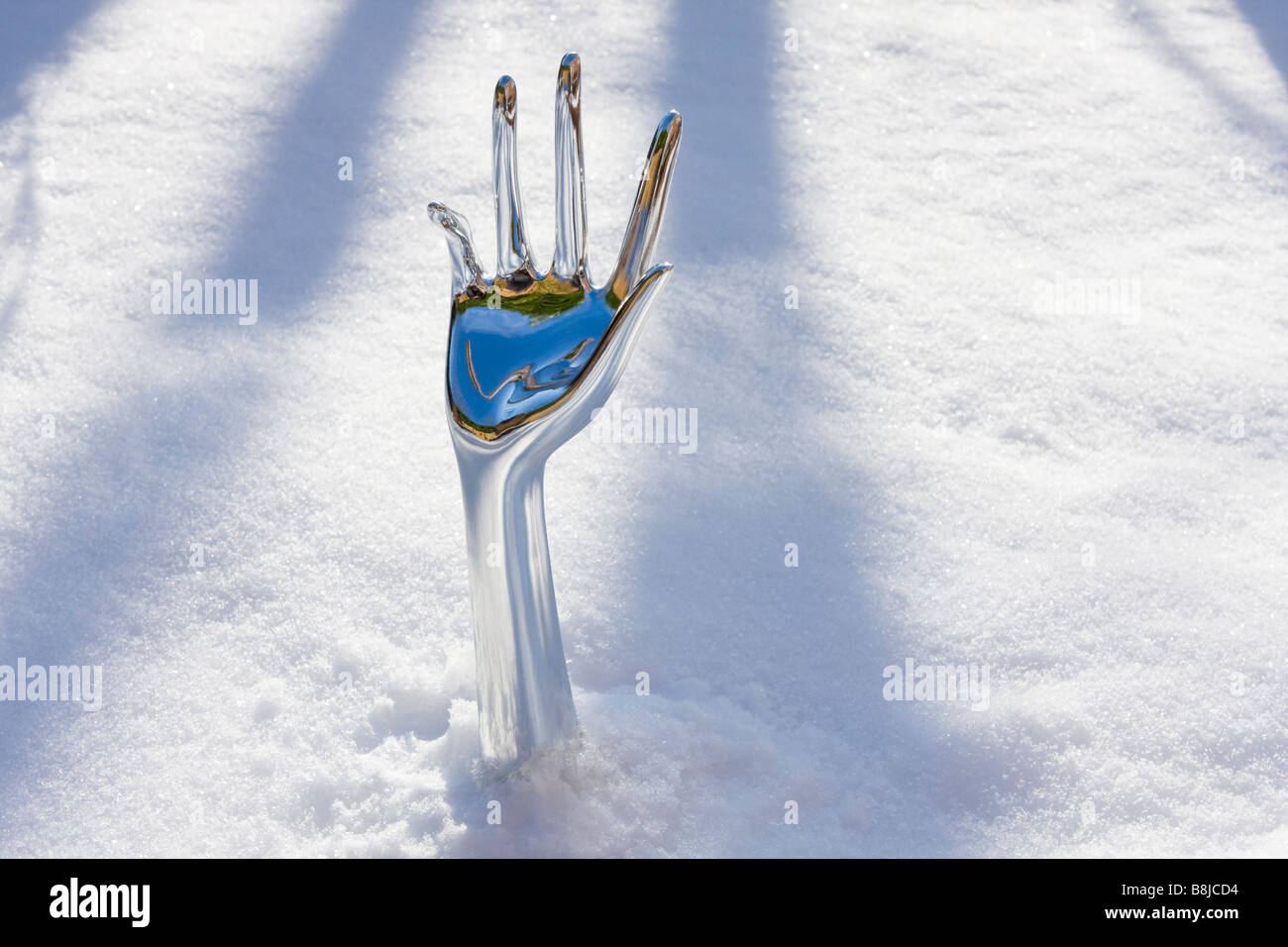 Metallic chrome hand reaching out from beneath snow Stock Photo - Alamy