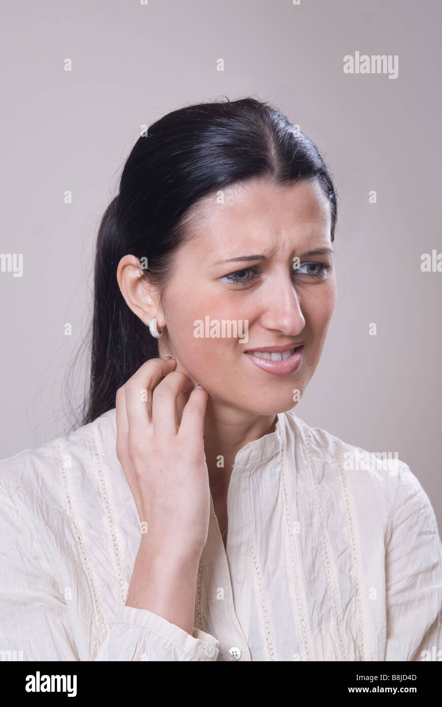Woman scratching neck Stock Photo - Alamy