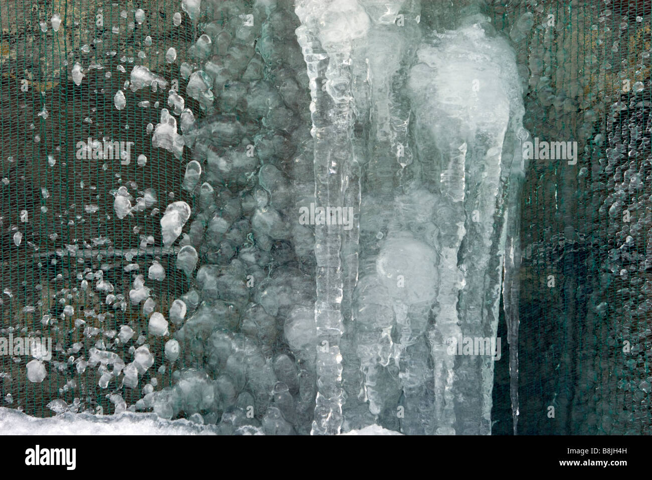 Frozen water isicles and drops over green net Stock Photo - Alamy