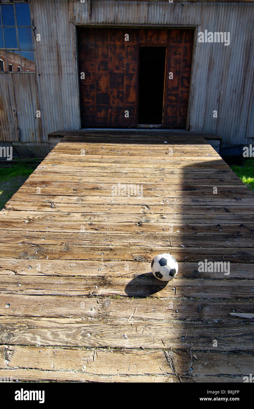 A soccer ball sits on an old loading dock, waiting for a game of futbol ...