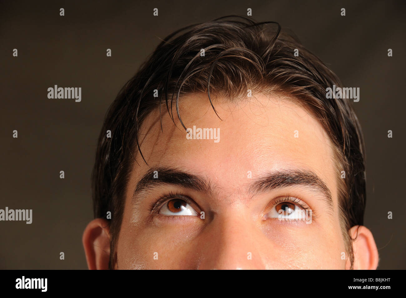 Detail of young male face with eyes looking up Stock Photo - Alamy
