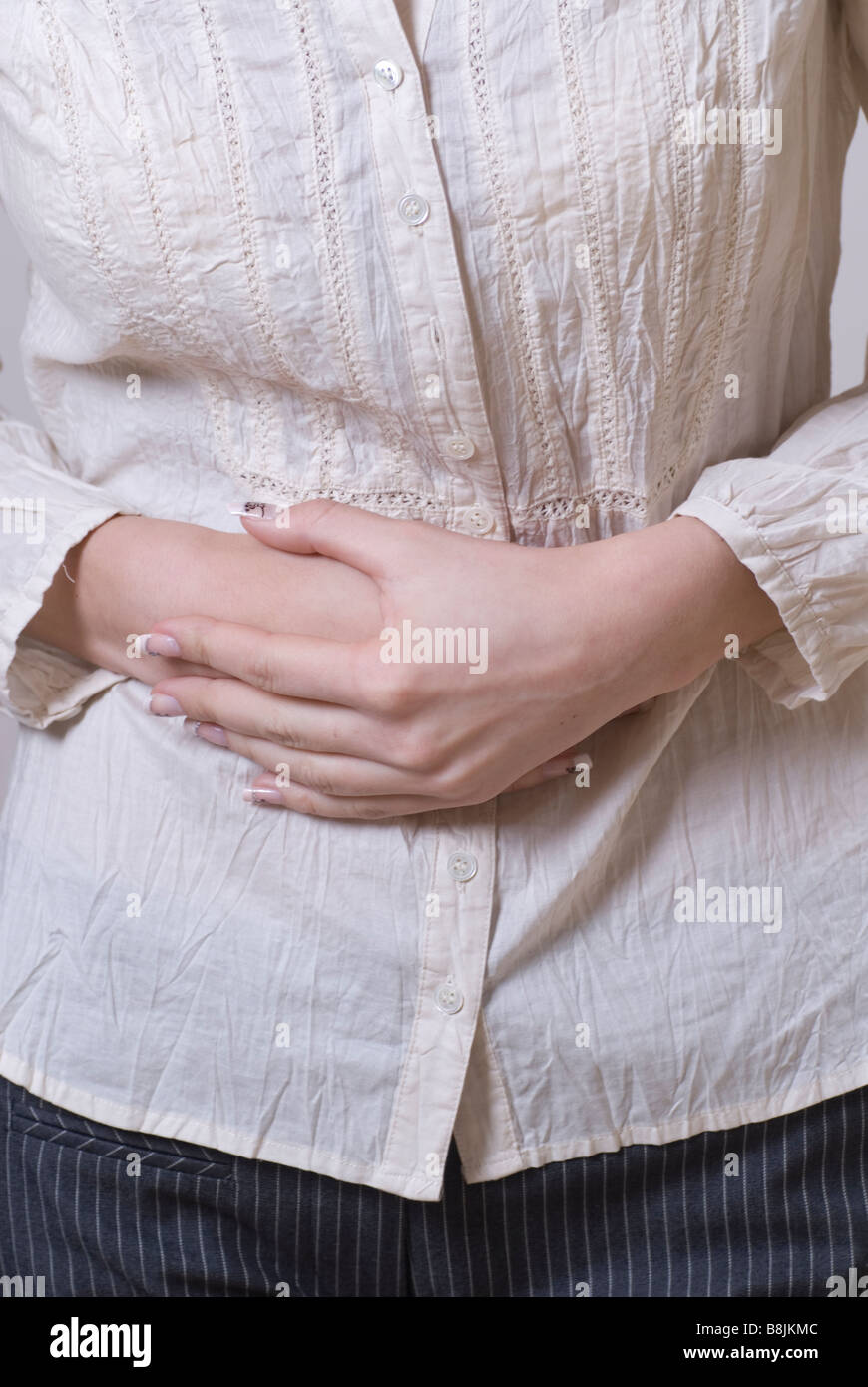 Woman hands over tummy Stock Photo - Alamy