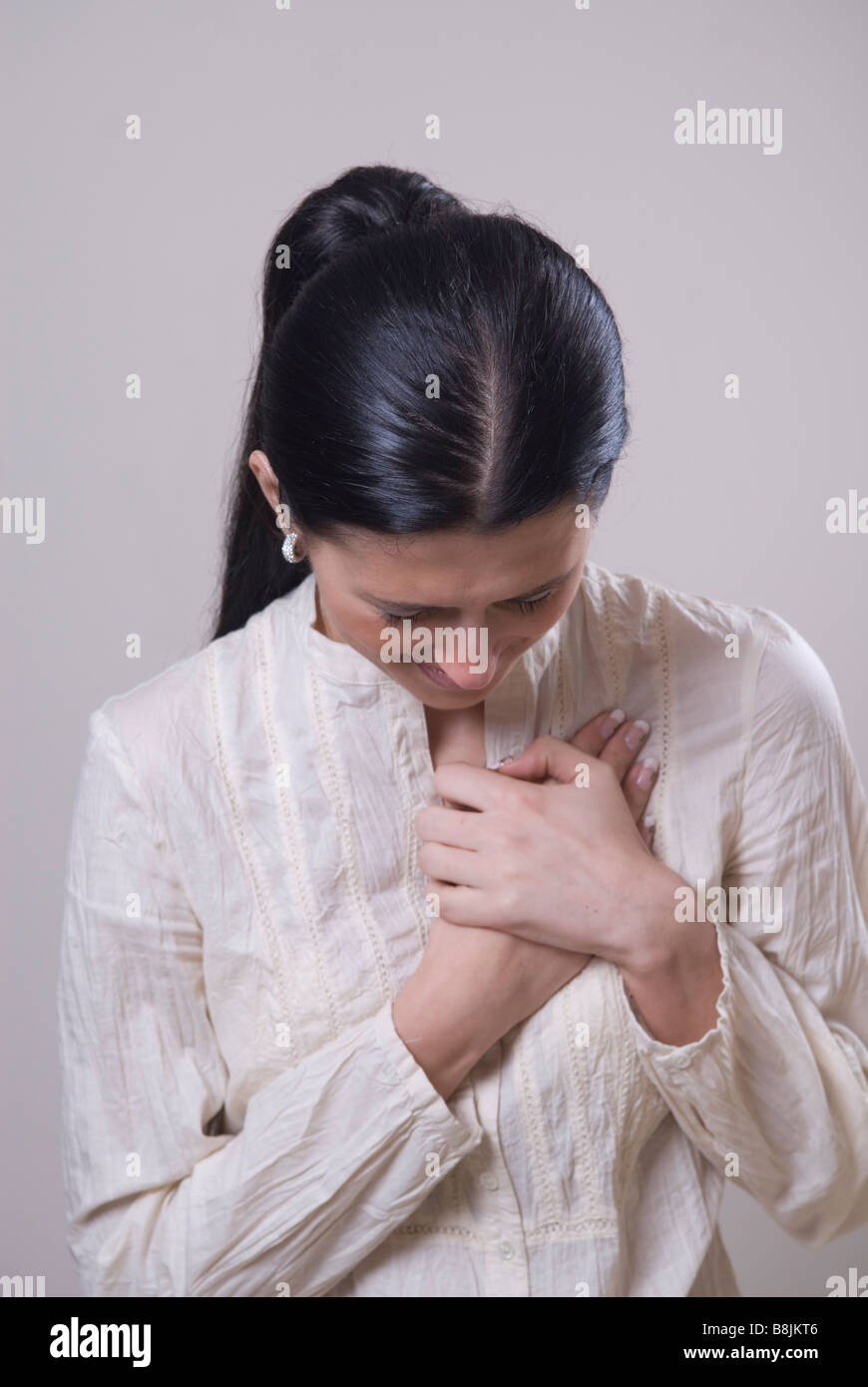 Young woman hands over heart Stock Photo - Alamy