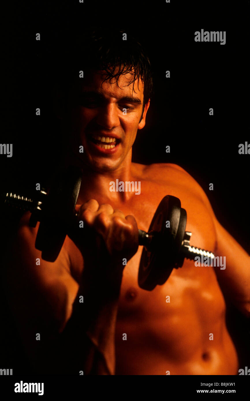 Man working out with hand weights Stock Photo - Alamy