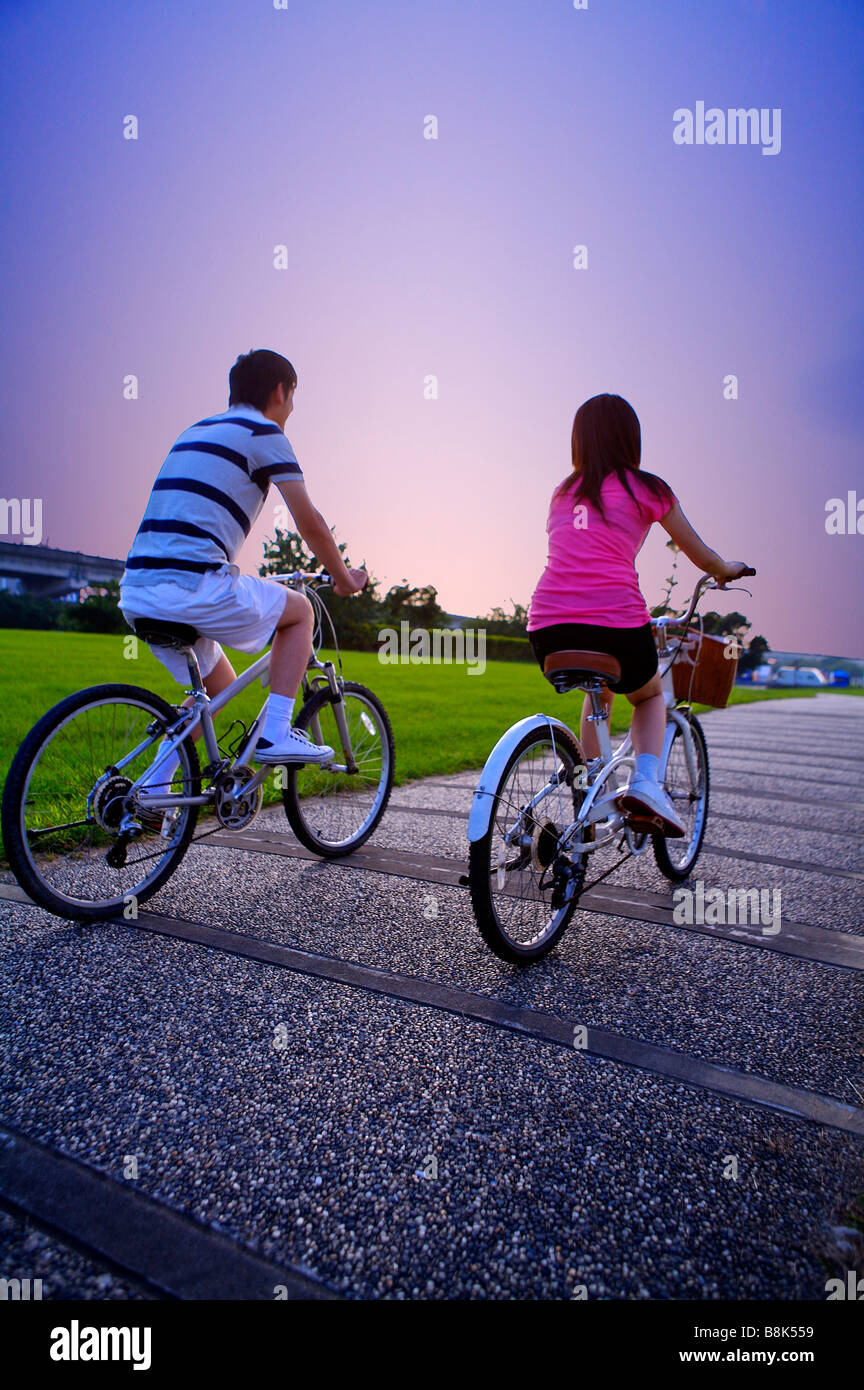 Young couple riding on the bicycles together Stock Photo - Alamy