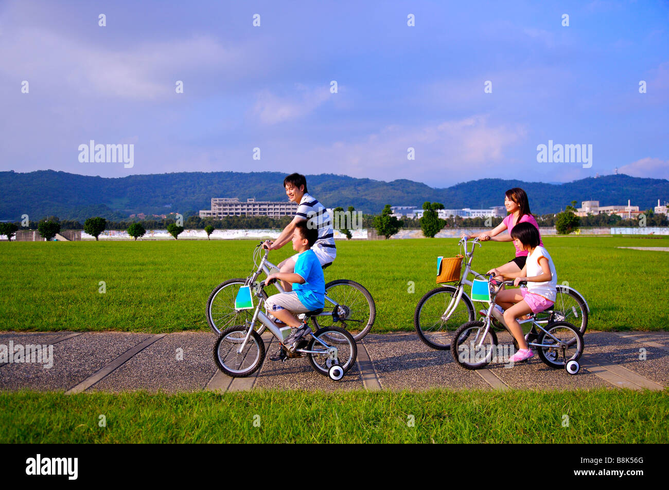Family with two children riding on the bicycles together Stock Photo ...