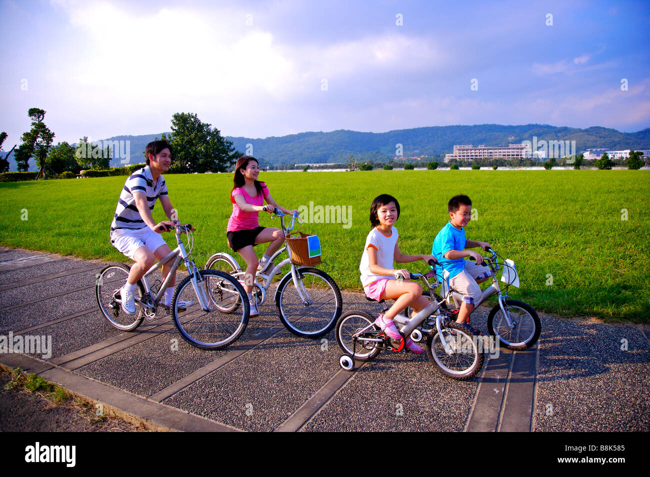 Family with two children riding on the bicycles together Stock Photo ...