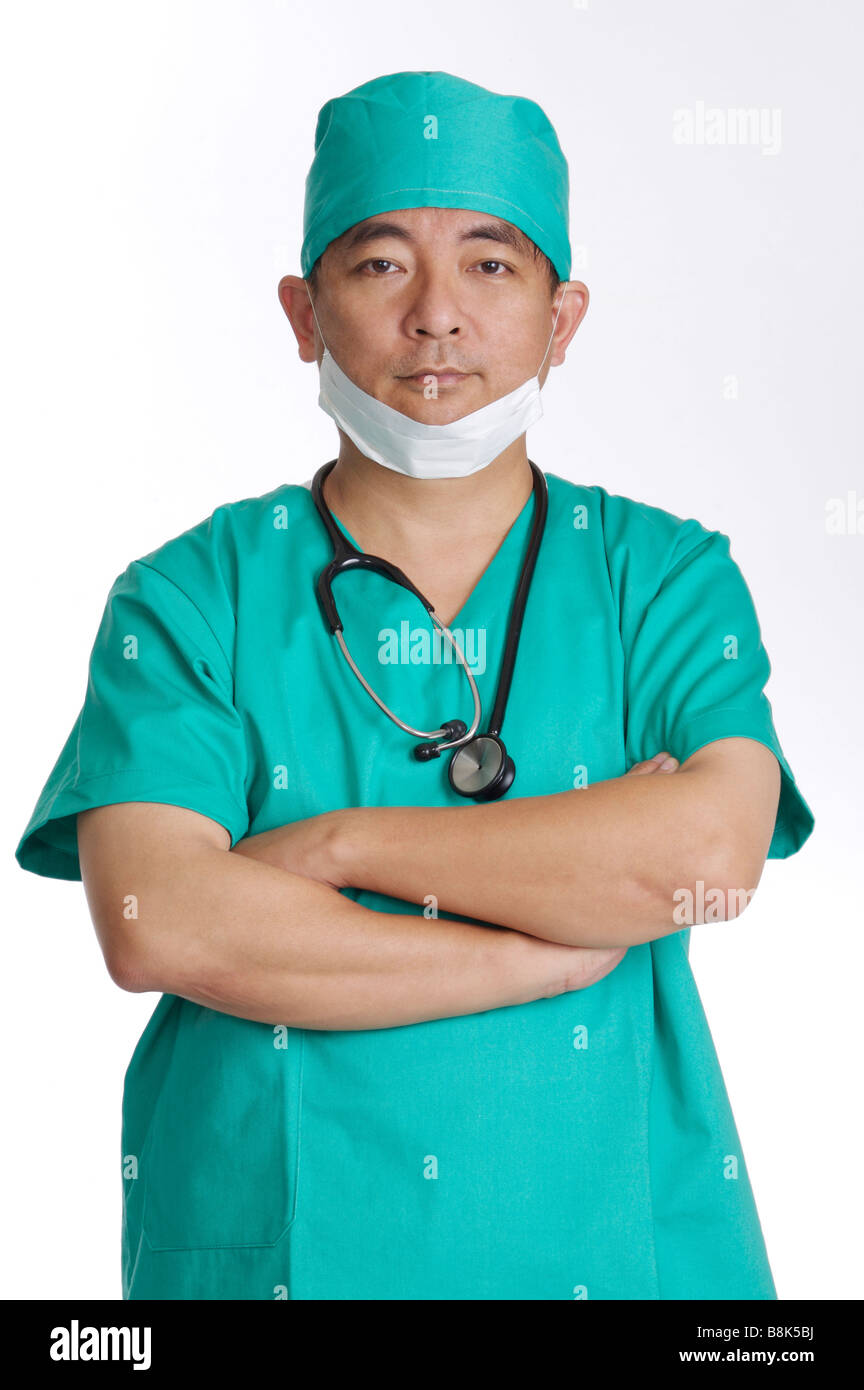 Doctor wearing operating gown and looking at the camera with hands on ...