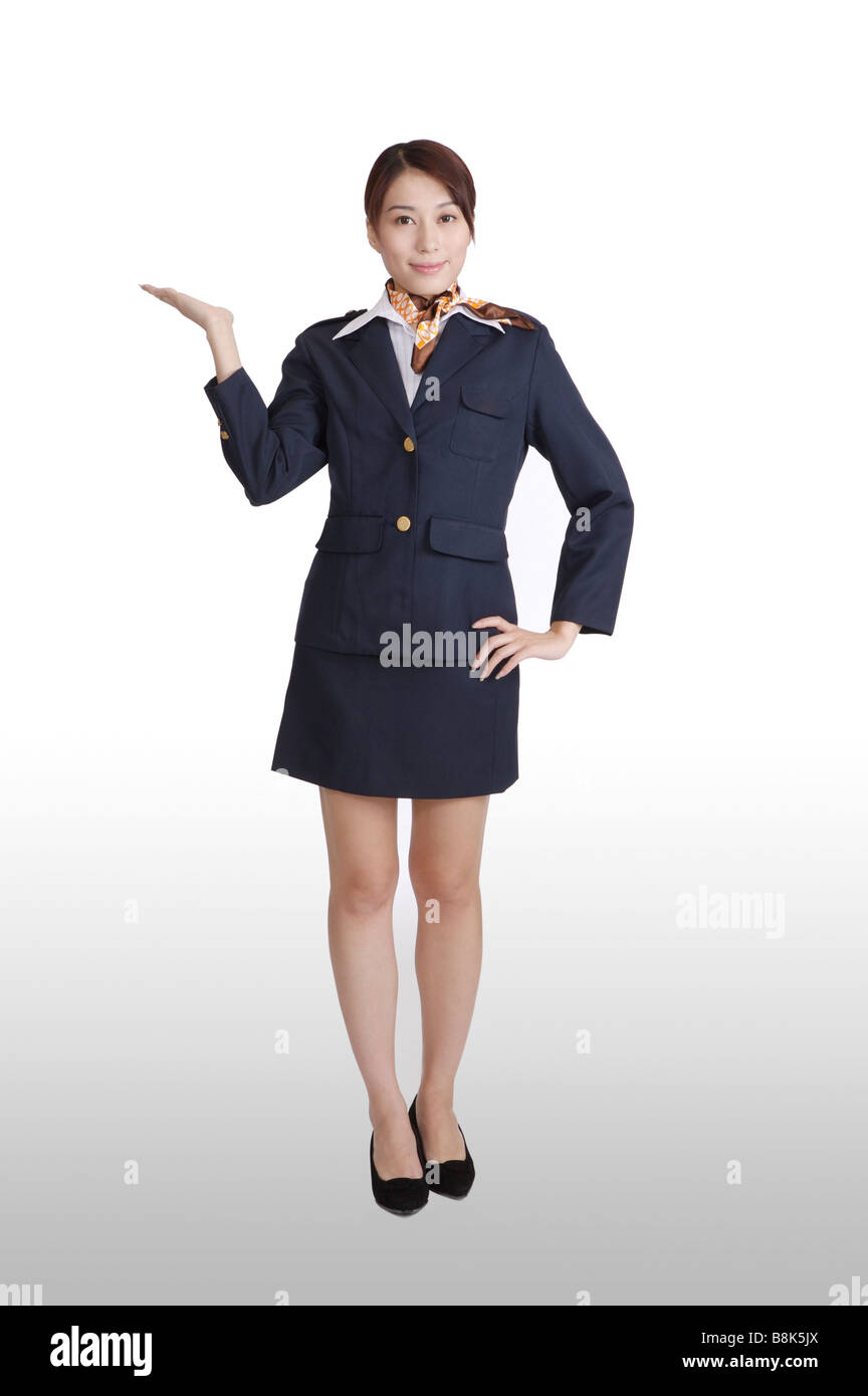 Young flight attendant gesturing welcome Stock Photo - Alamy