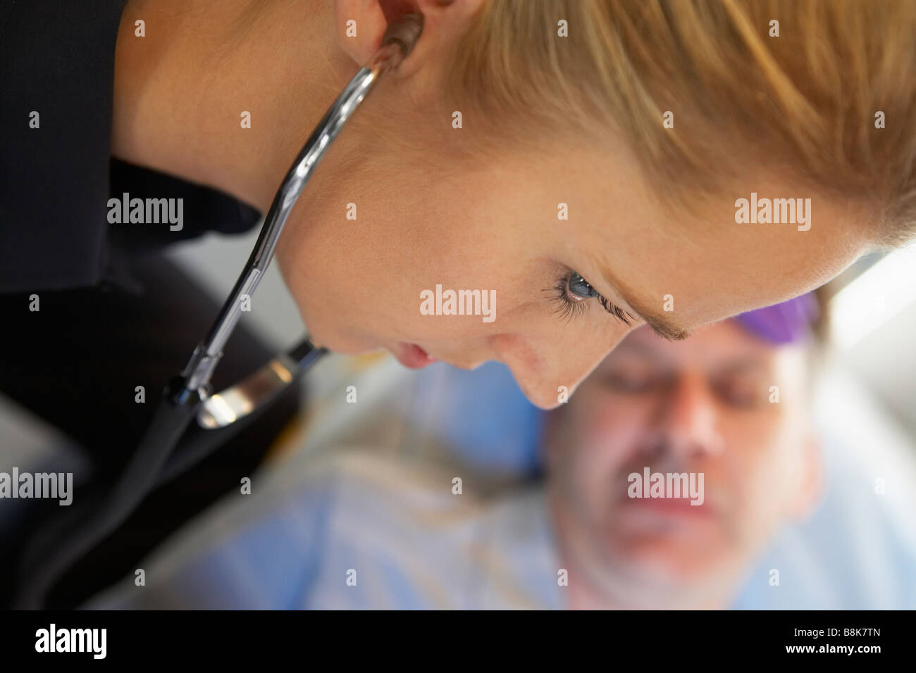 Paramedic using stethoscope on patient in ambulance Stock Photo - Alamy
