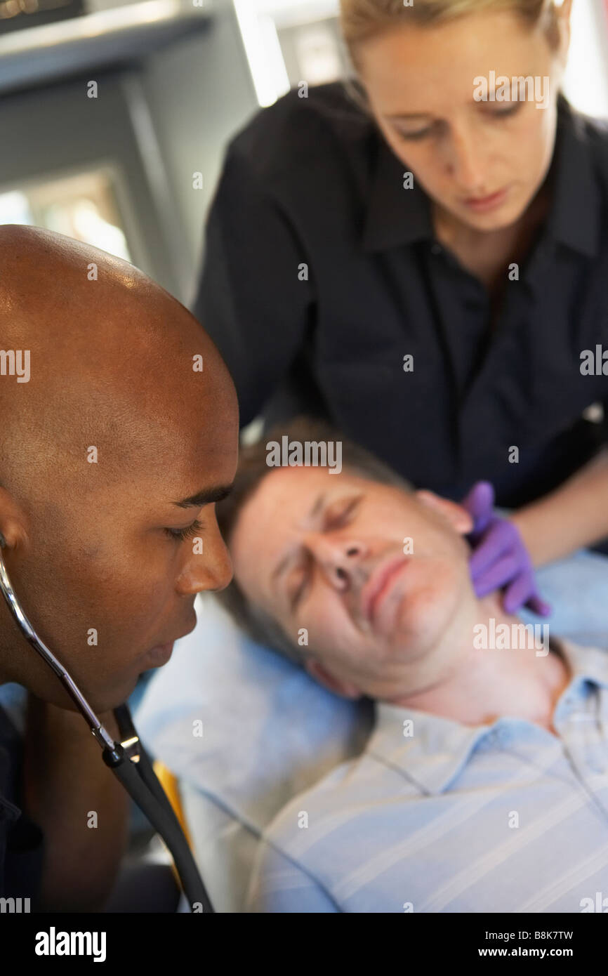 Paramedic using stethoscope on patient in ambulance Stock Photo - Alamy