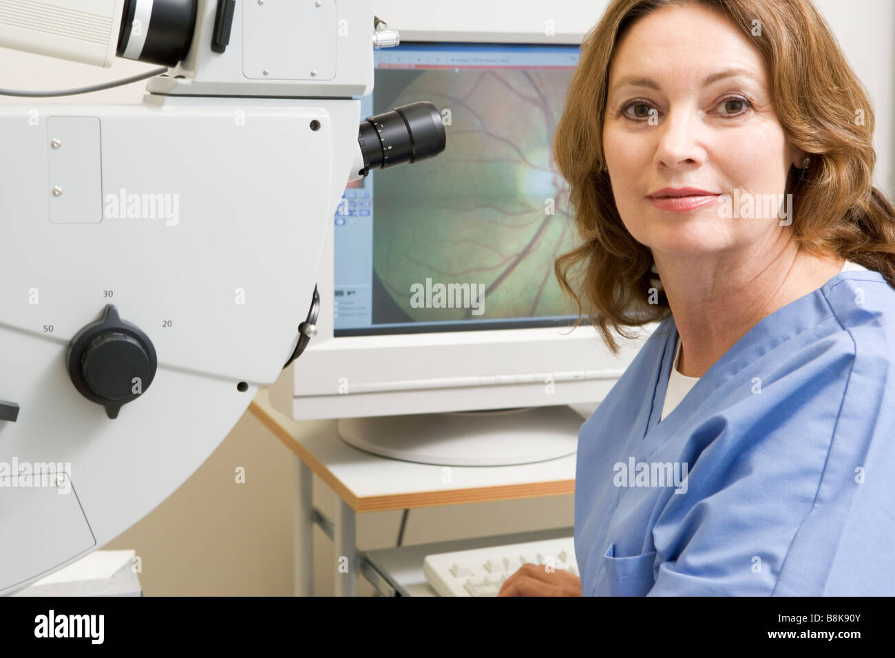 Portrait Of A Nurse Next To An Eye Exam Machine Stock Photo - Alamy