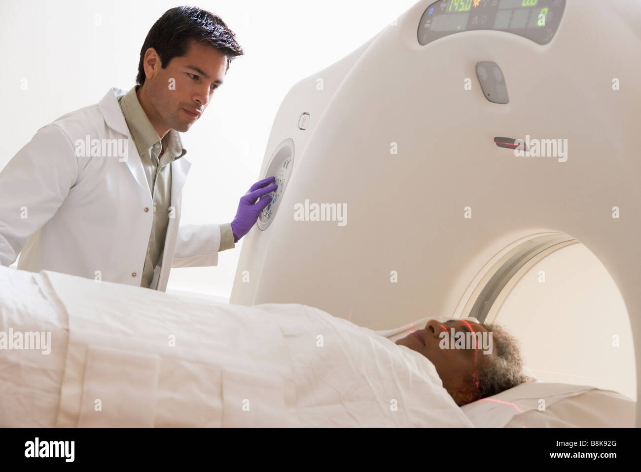 Doctor With Patient Having A Computerized Axial Tomography (CAT) Scan ...