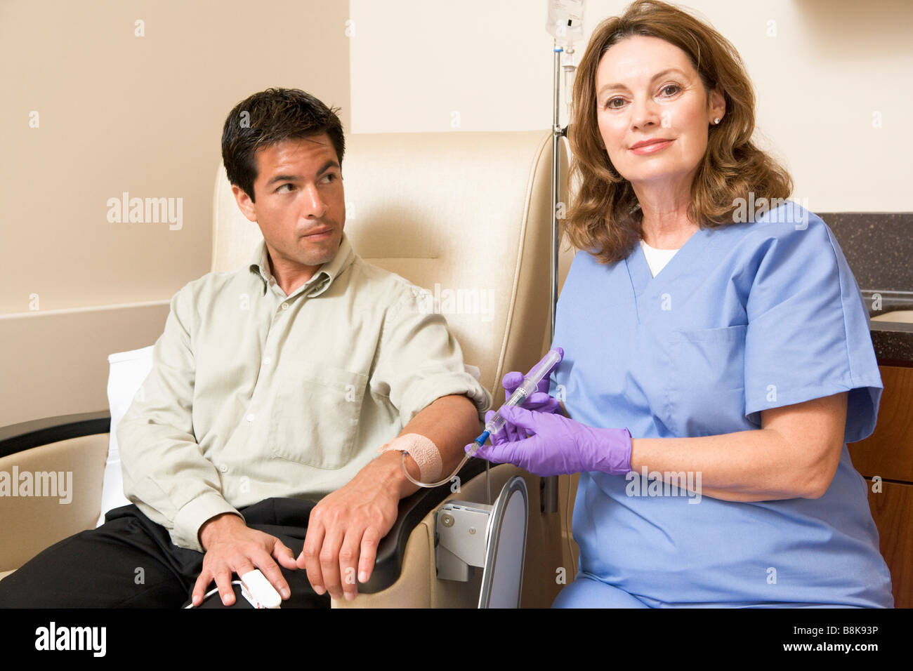 Nurse Giving Patient Injection Through Tube Stock Photo - Alamy