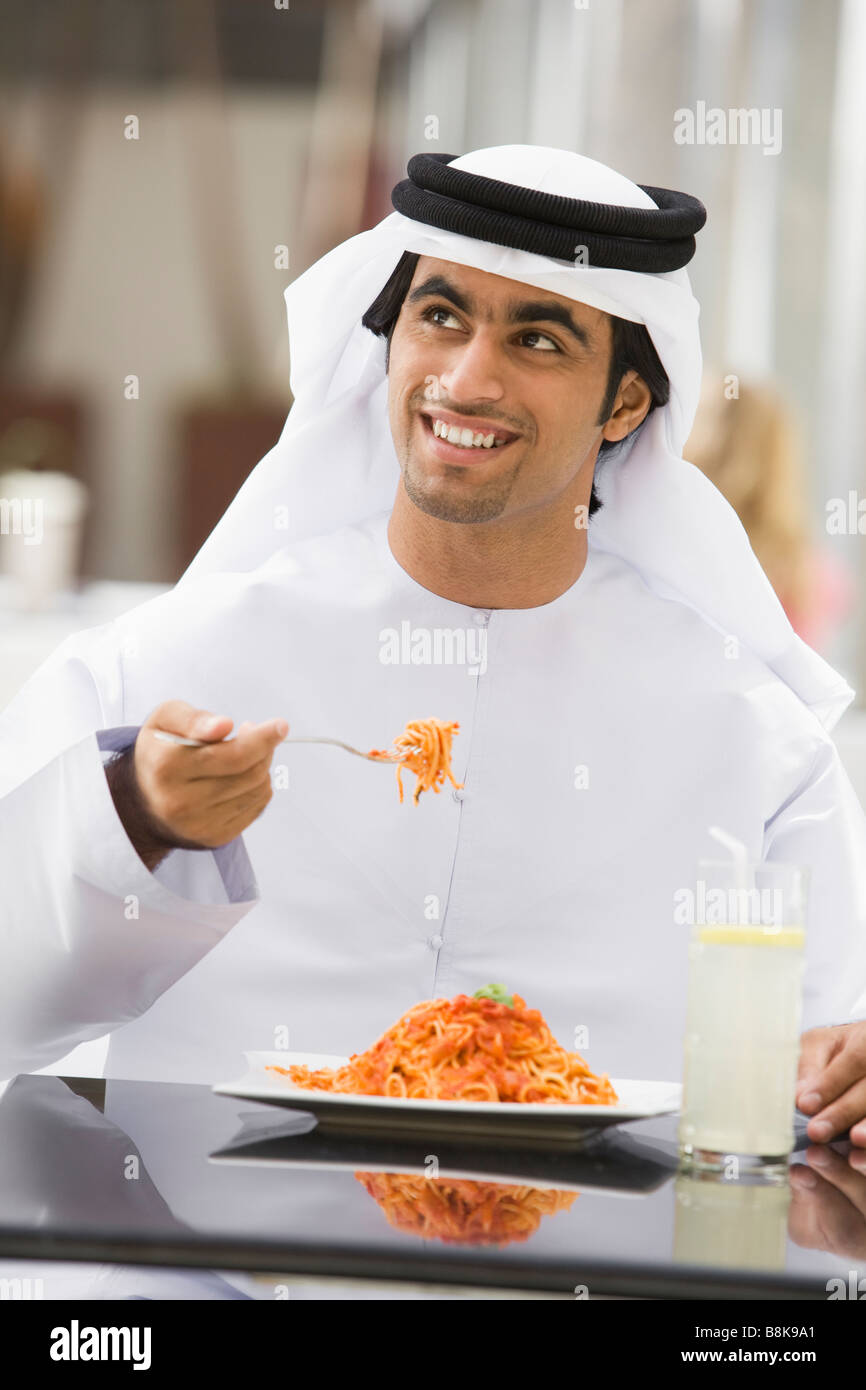 Man at restaurant eating spaghetti and smiling (selective focus Stock ...
