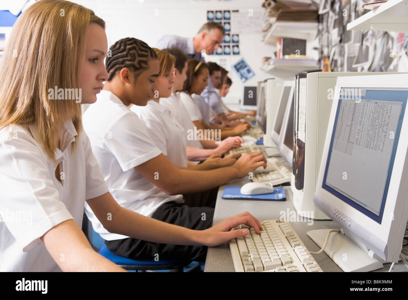 Students working on computer workstations with teacher Stock Photo - Alamy
