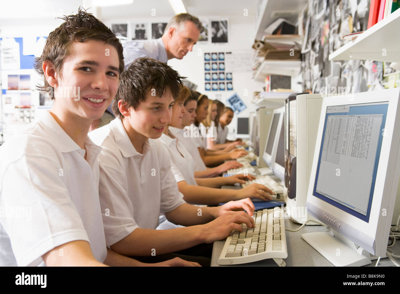 Students working on computer workstations with teacher Stock Photo - Alamy