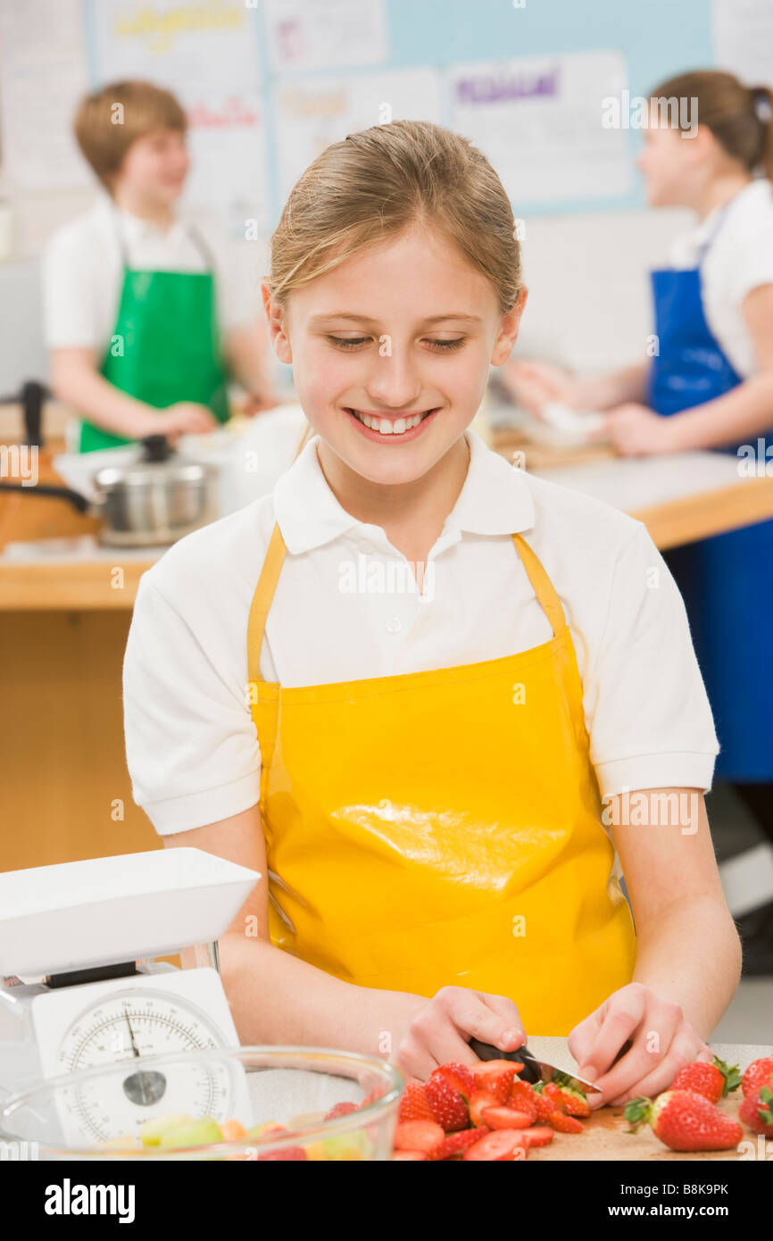 Female student slicing berries in cooking class Stock Photo - Alamy