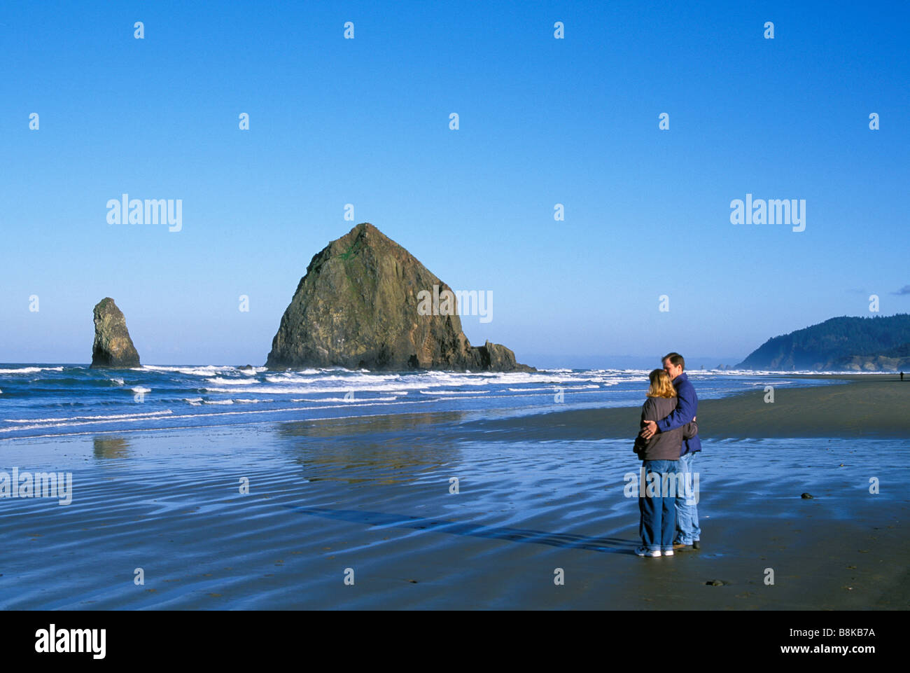 Couple on beach and Haystack Rock Cannon Beach northern Oregon coast ...