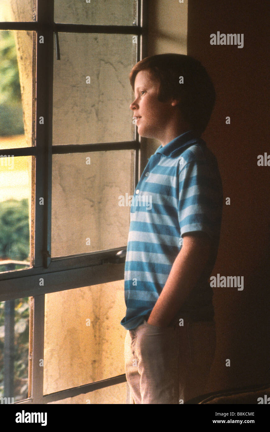 boy serious face direct look stare portrait window intent sad angry mad ...