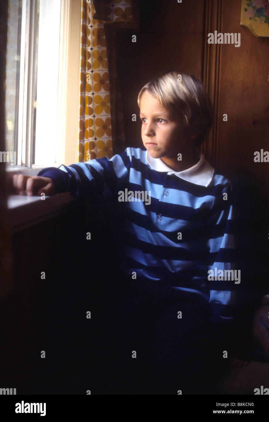 boy serious face direct look stare portrait window intent sad angry mad ...