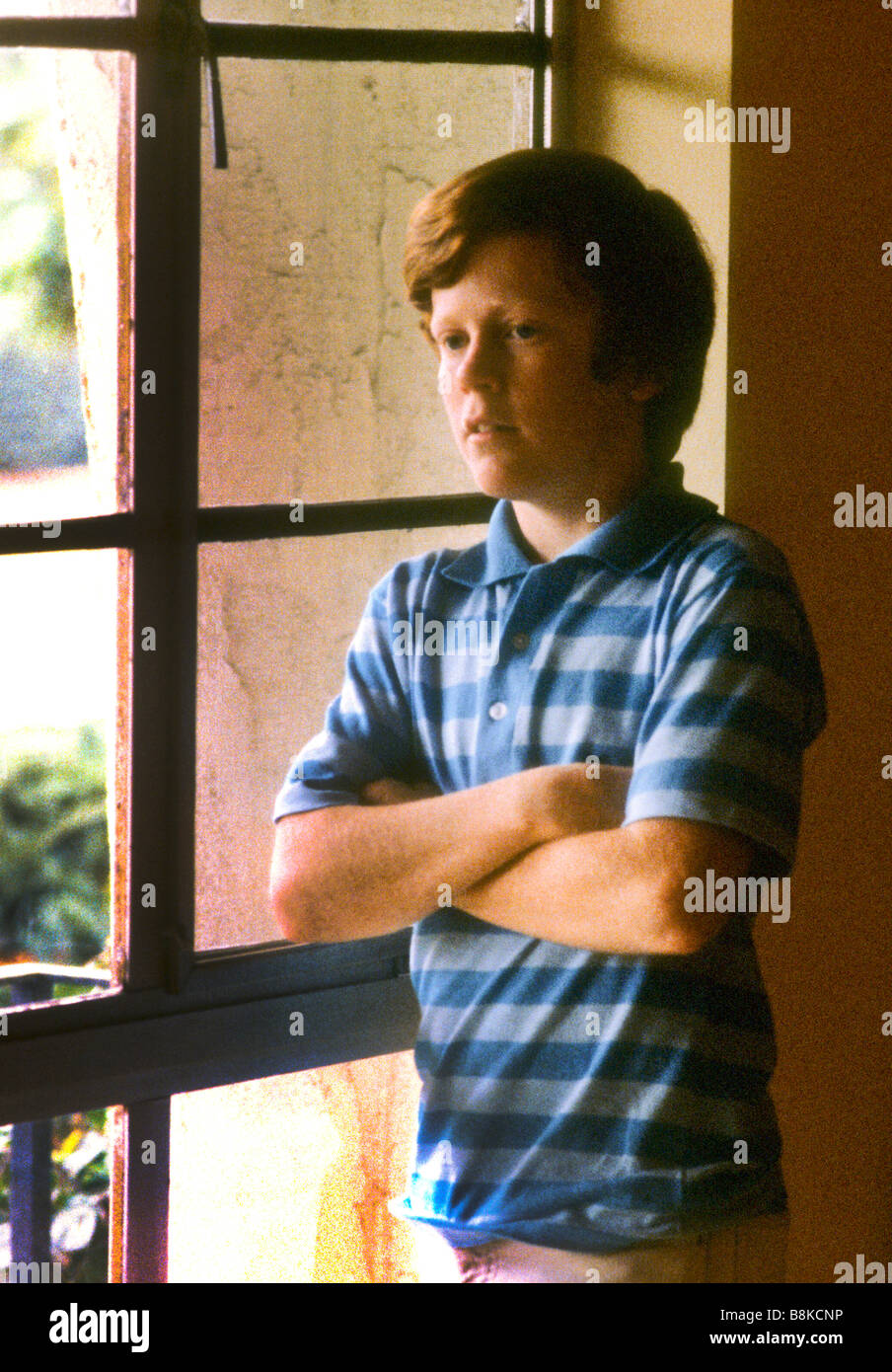 boy serious face direct look stare portrait window intent sad angry mad ...