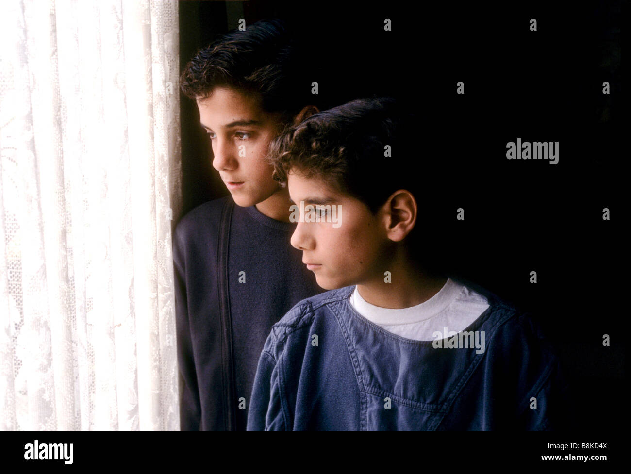 Twin brother look out window serious sad concern worry worried profile ...