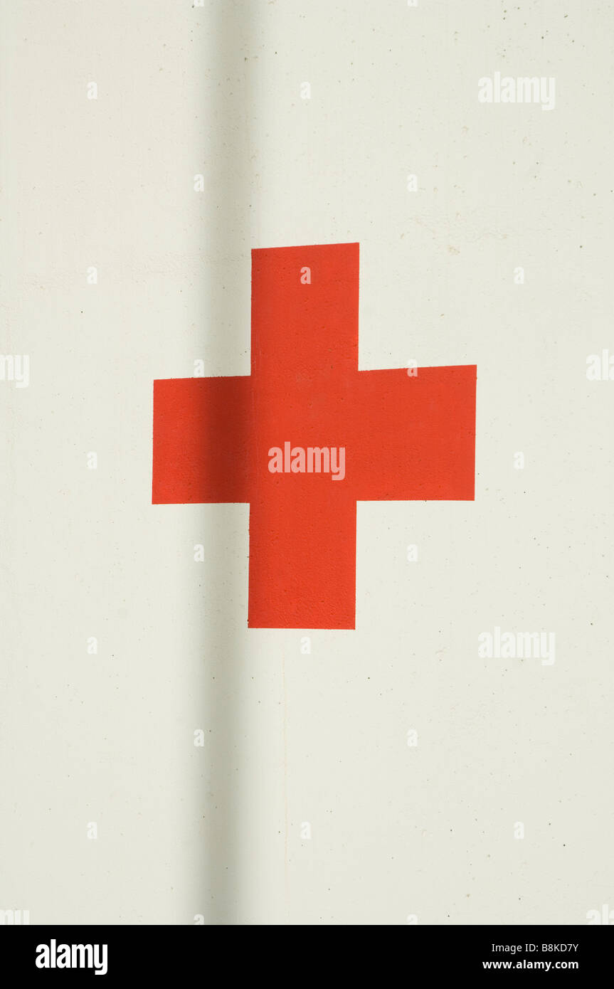 Painted red cross on white outside plaster wall Stock Photo - Alamy
