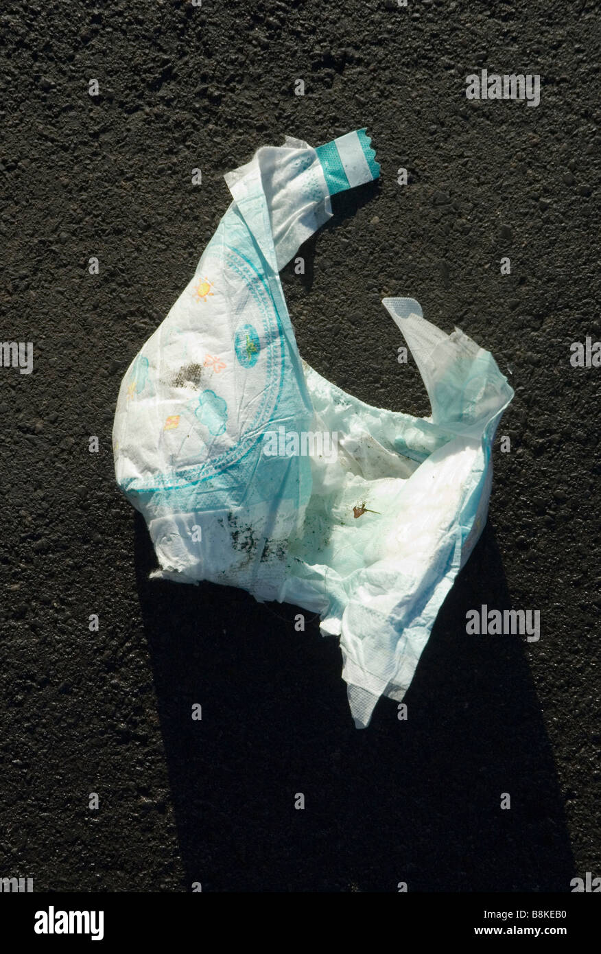 Looking down on a disposable nappy which has been left by the side of a ...