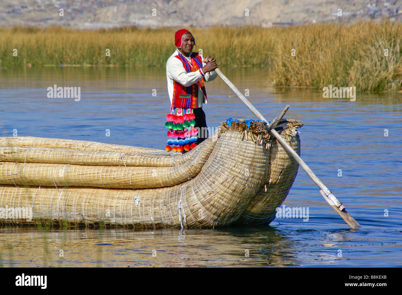 Uros Indian man in tortora reed boat on Lake Titicaca, Peru Stock Photo ...