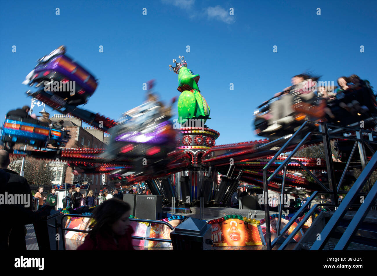 People riding an amusement park ride in bright sunshine are riding so ...