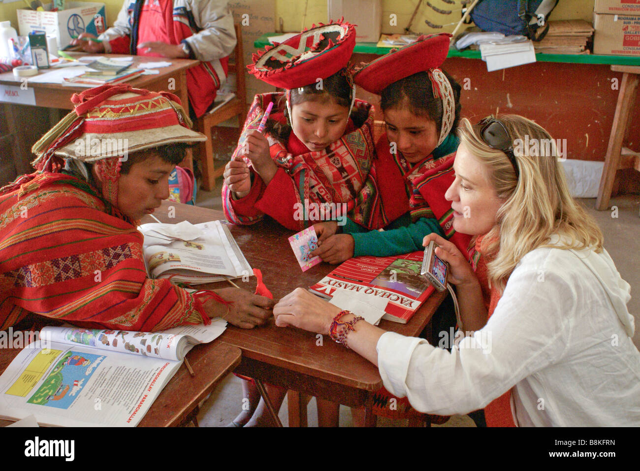 Tourist with Quechua Indian children in classroom, Willoq, Urubamba ...