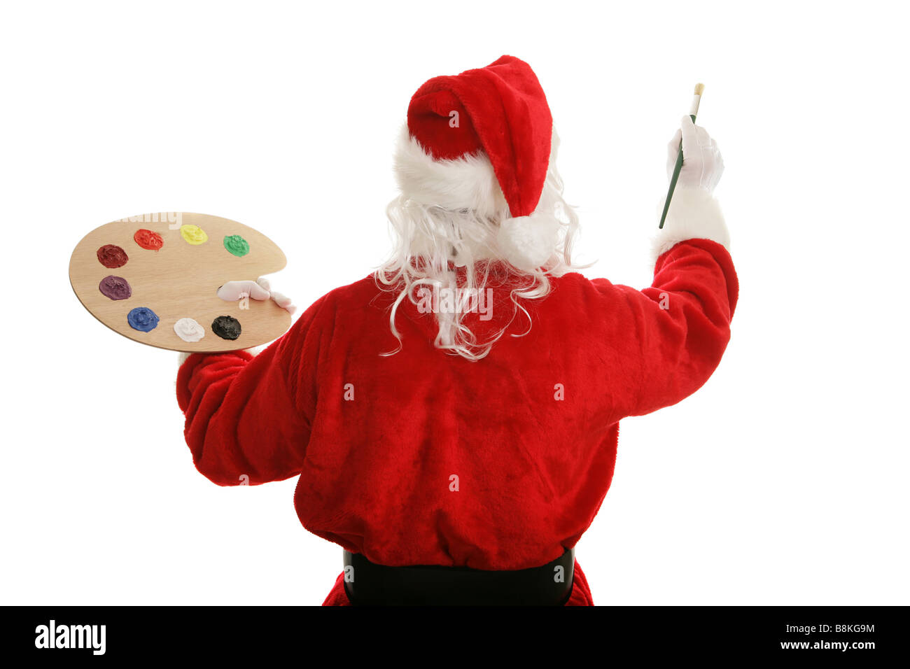 Rear view of Santa Claus with a paint palette and artists brush as he ...