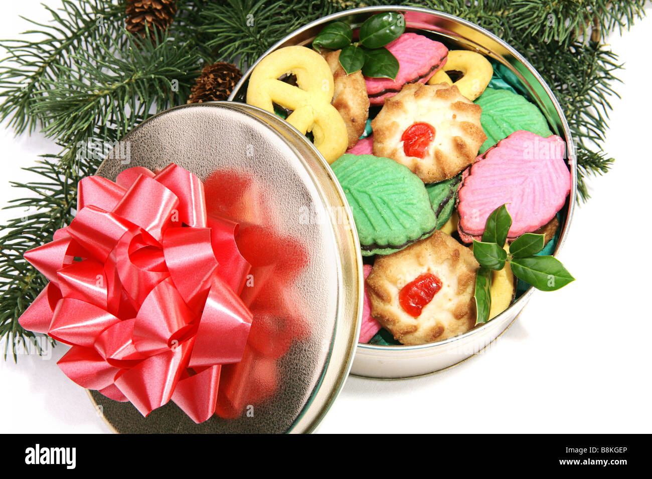 A tin of delicious colorful holiday cookies nestled under the Christmas ...