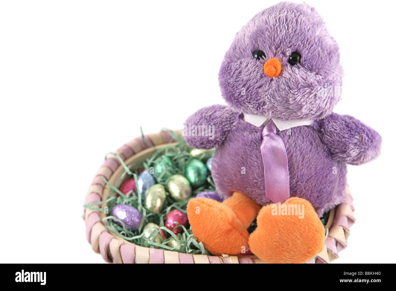 A stuffed easter chick sitting in a basket of chocolate eggs White ...