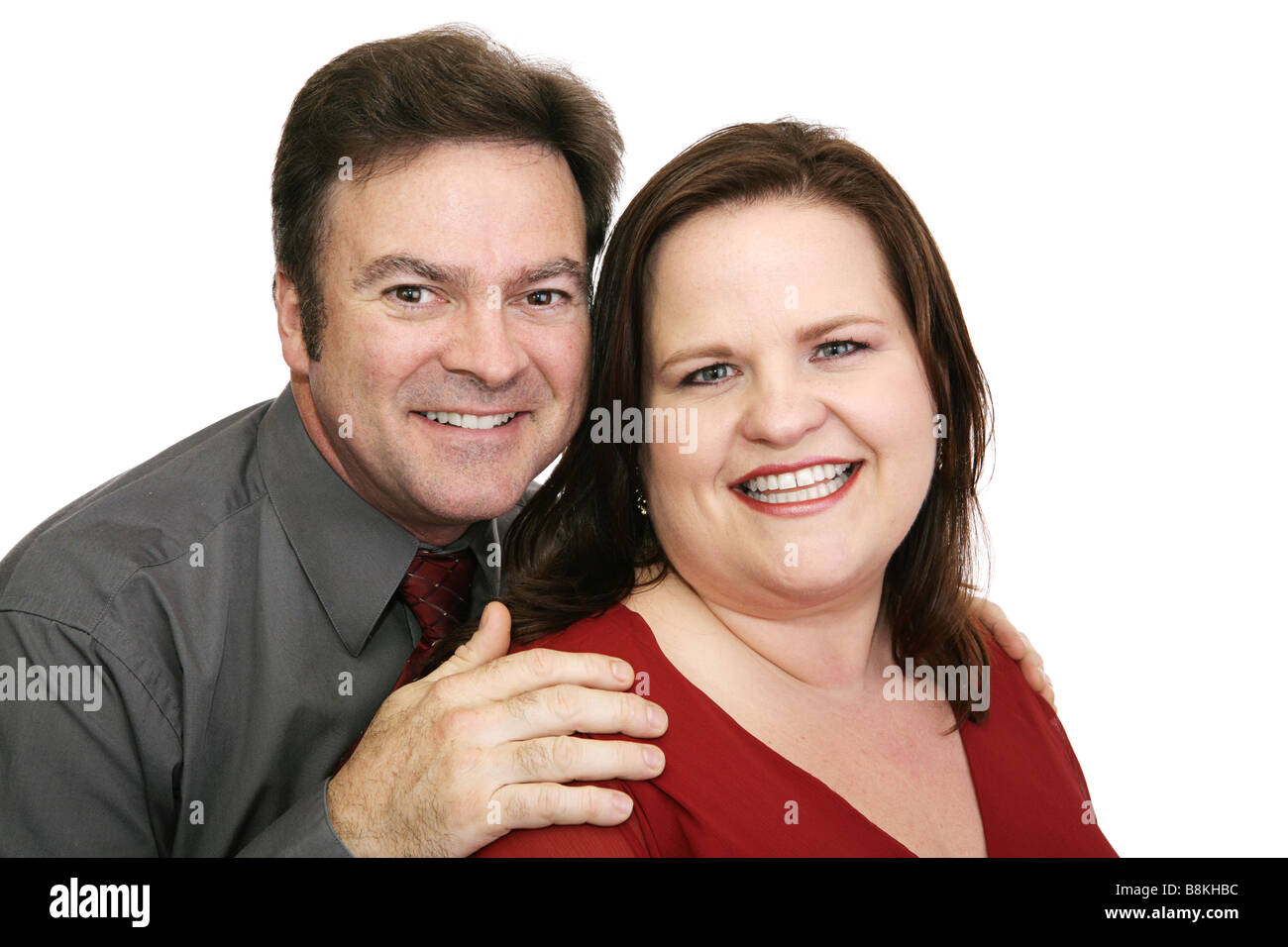 A good looking loving couple in red her dress his tie Isolated on white ...