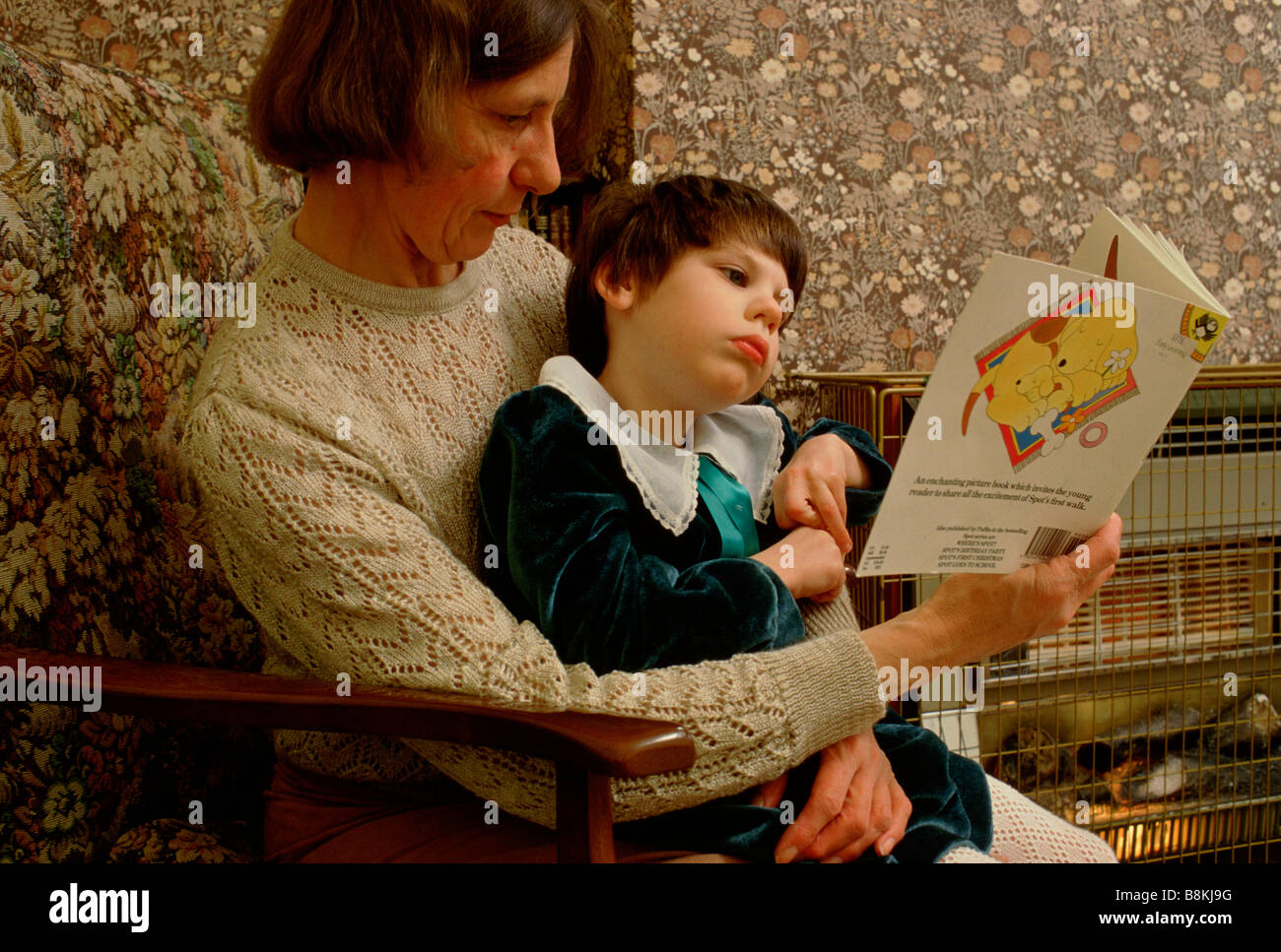 A single parent raising a handicapped child reads to her child Stock ...