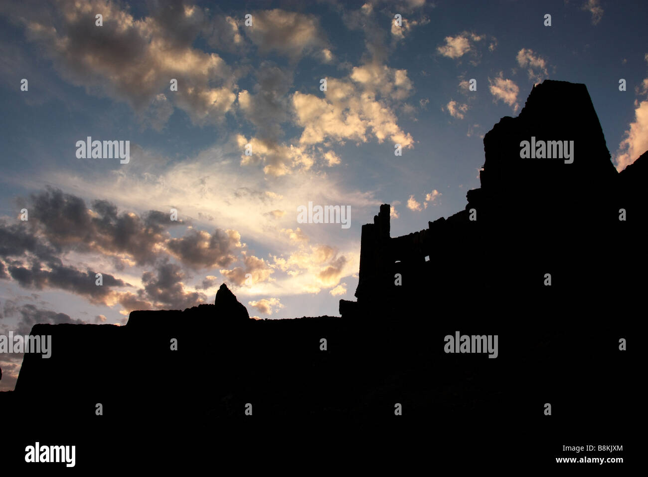 Deserted Kasbah town at dusk. A partially collapsed mud built tower in ...