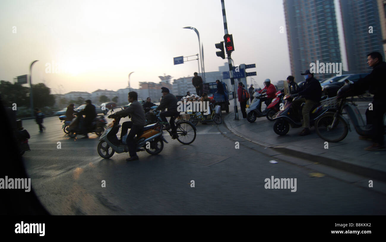 A crowd of people driving mopeds and motor scooters, and riding ...