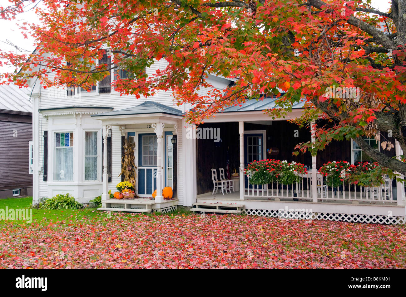 A large white home with veranda and fall foliage in rural Vermont USA ...