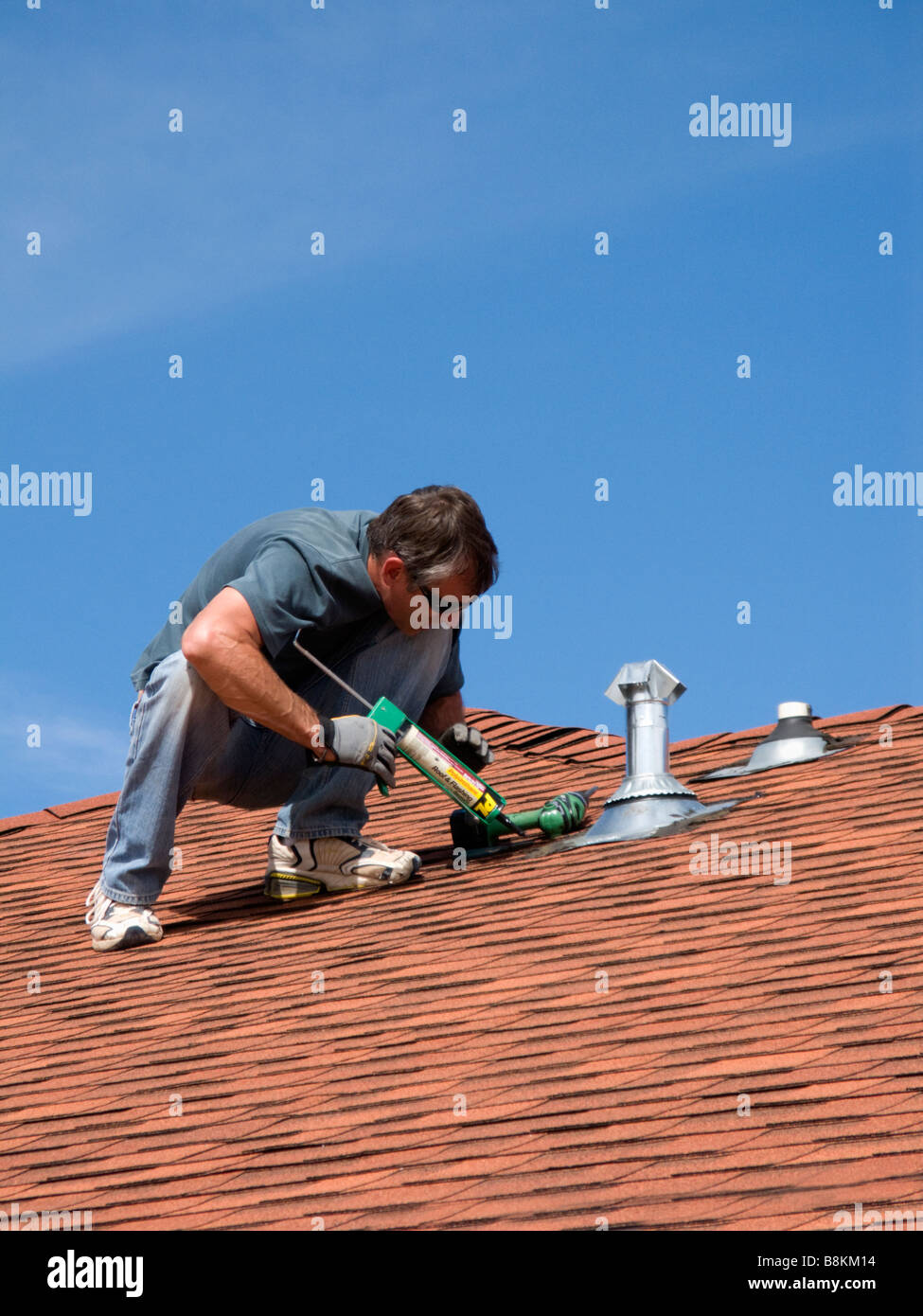 Man working on roof Stock Photo - Alamy