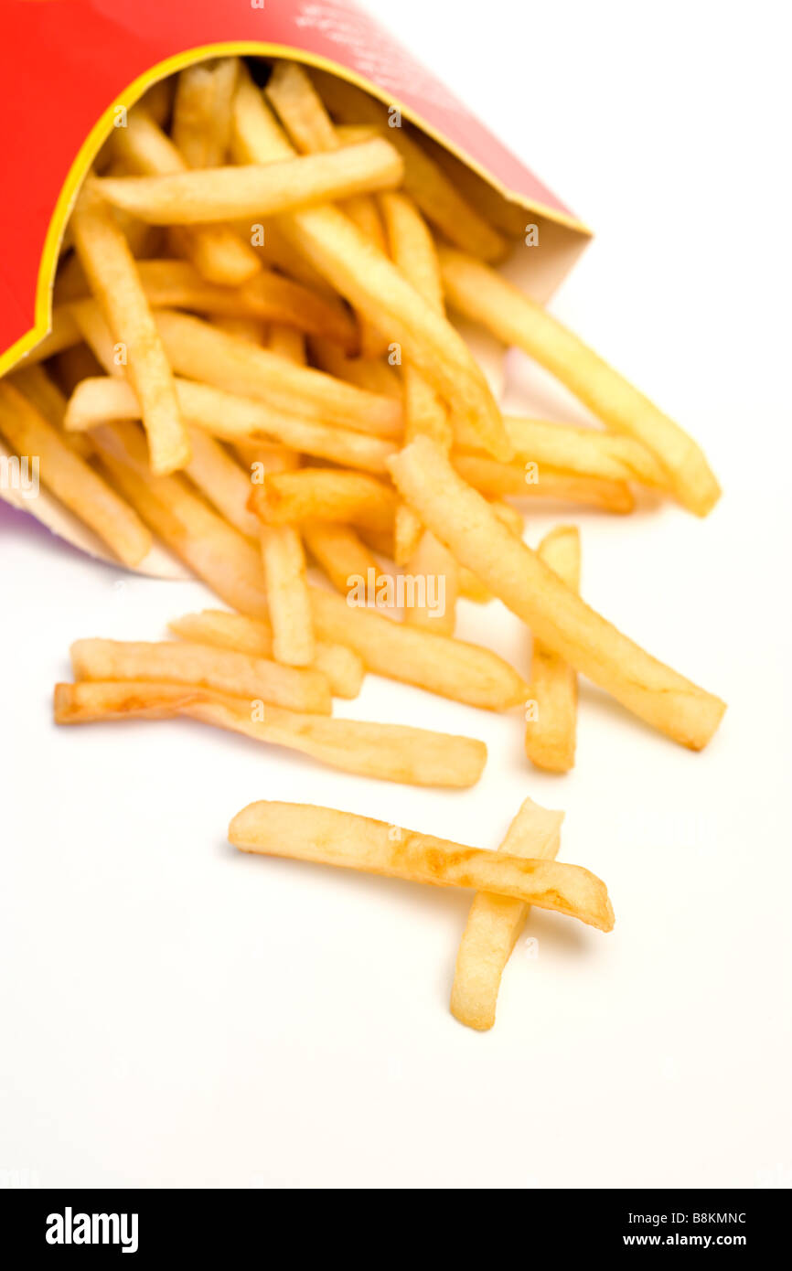 Unhealthy fast food. French fries falling from tilted cardboard box ...