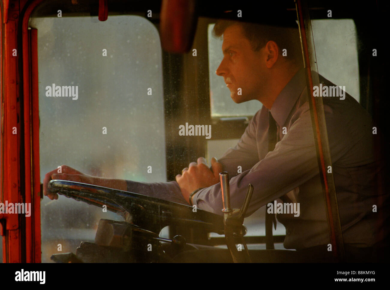 London, England: A bus driver sits inside the cab of his routemaster ...