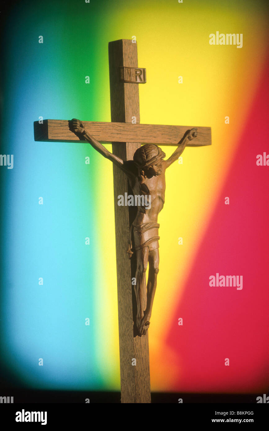 Carved wooden crucifix against rainbow background Stock Photo - Alamy