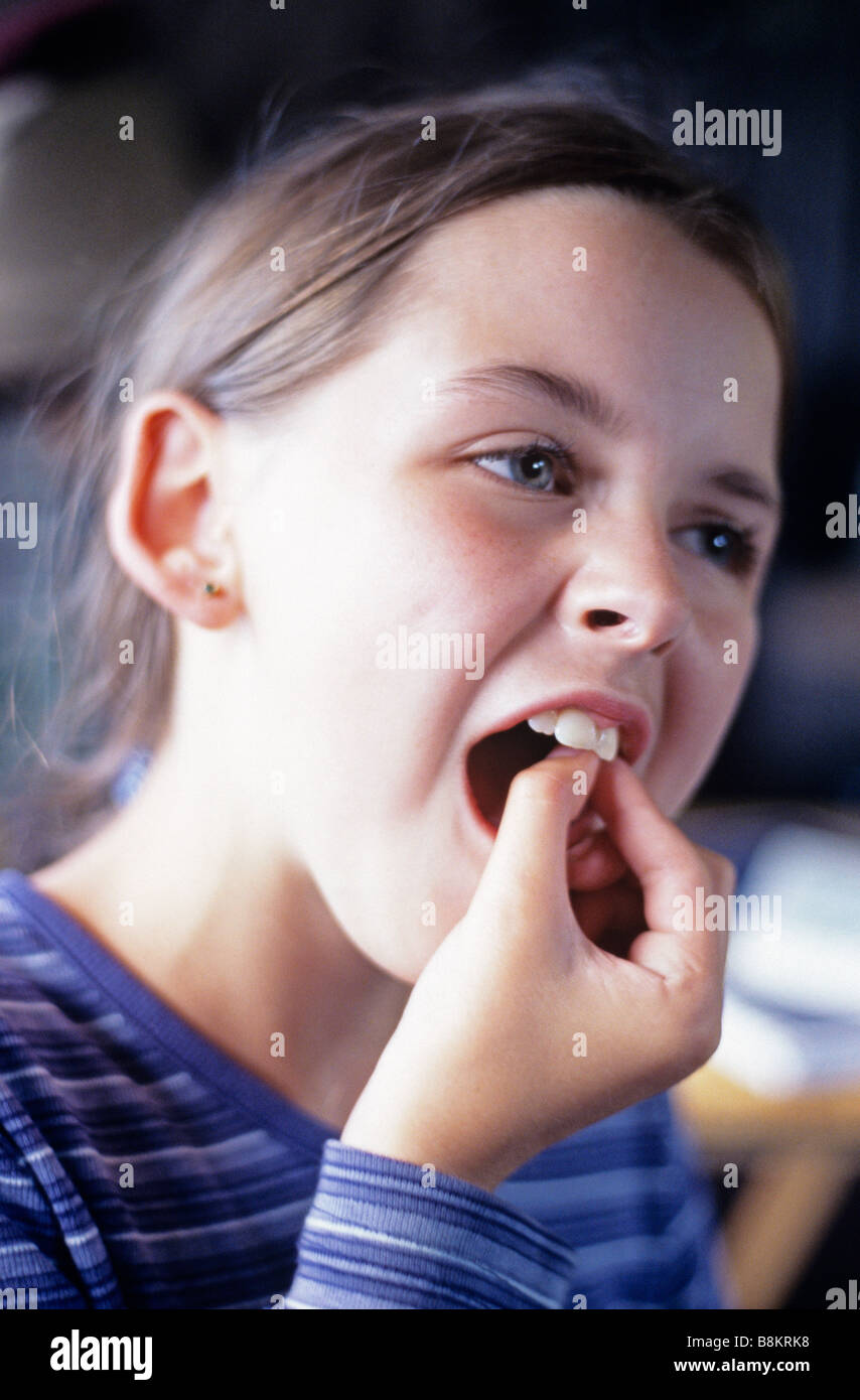 Girl pulling tooth with fingers Stock Photo - Alamy