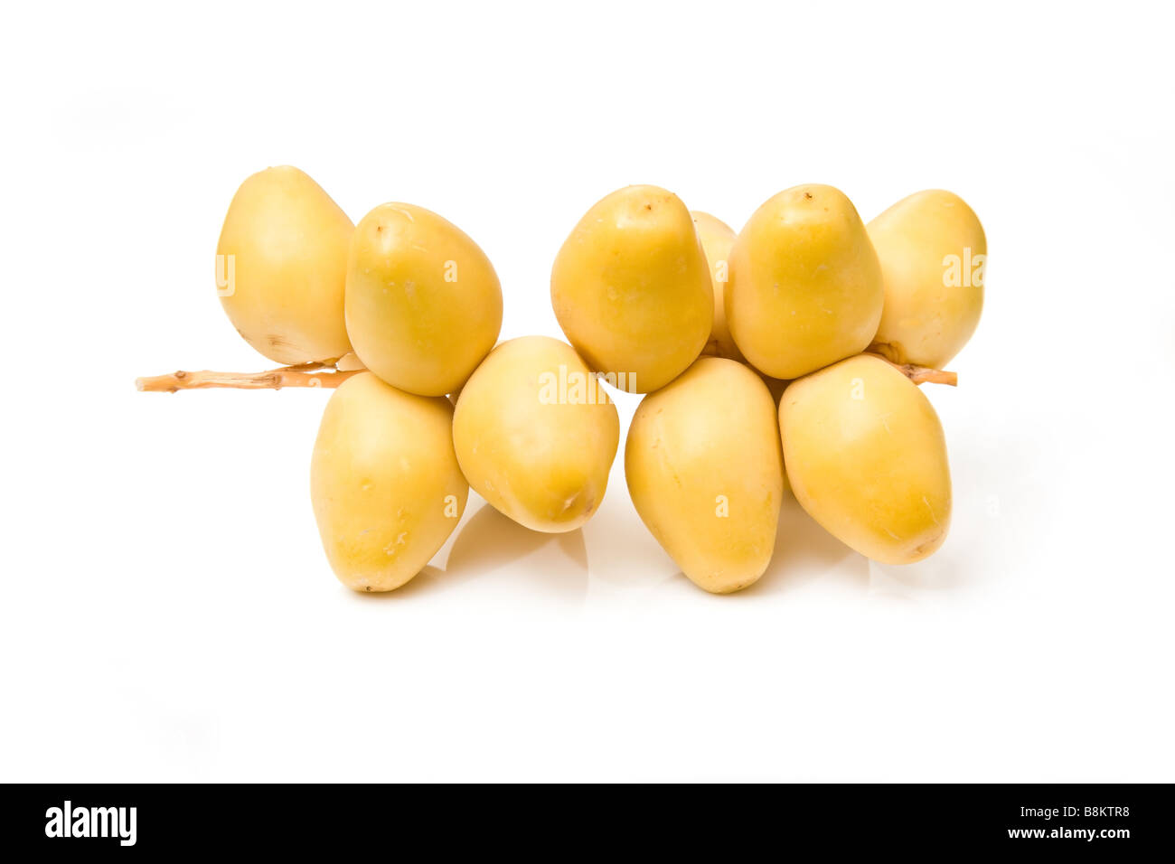 Yellow dates isolated on a white studio background Stock Photo - Alamy